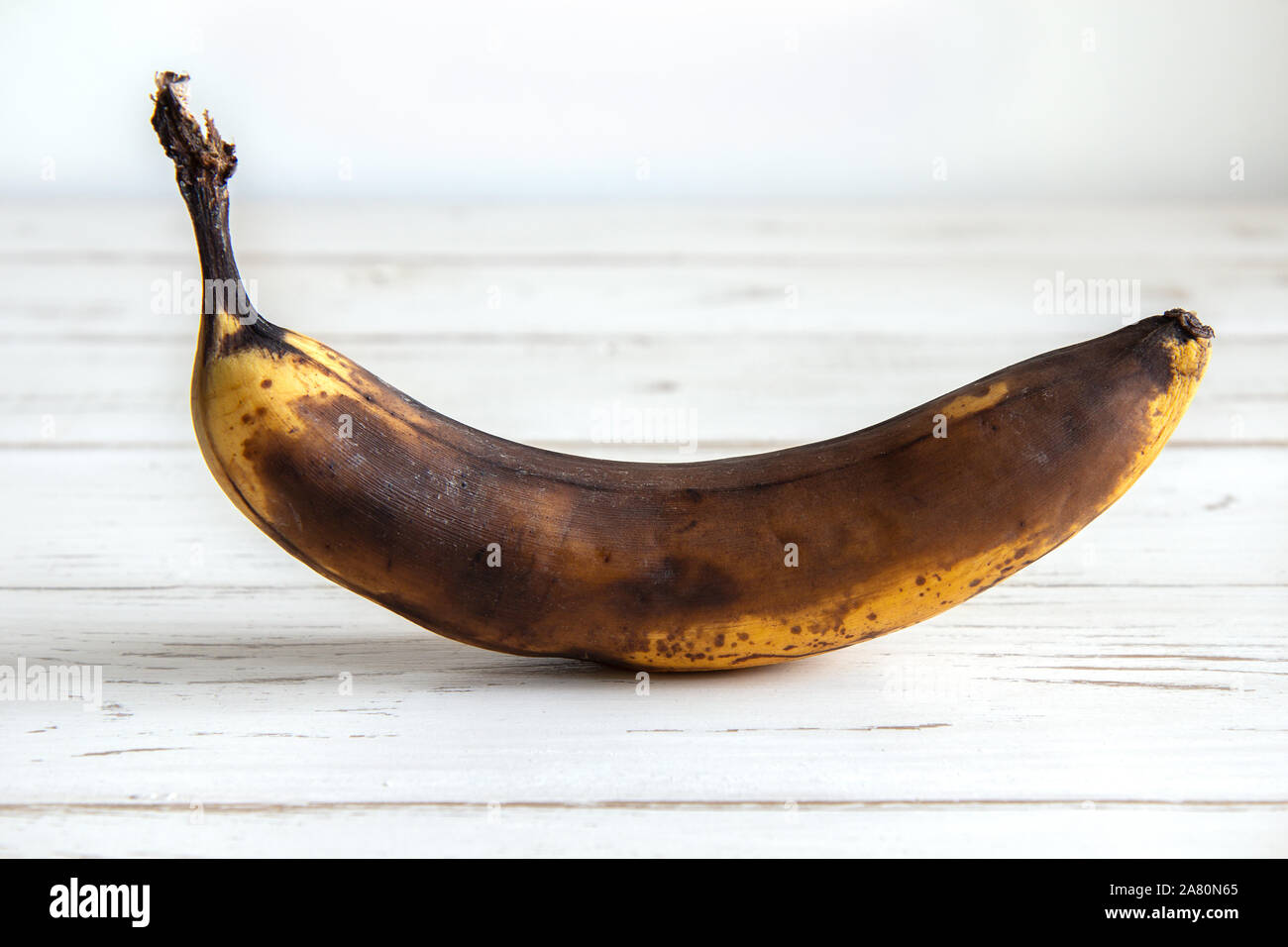 Ugly food. Dark banana spoiled over time on a white background ...