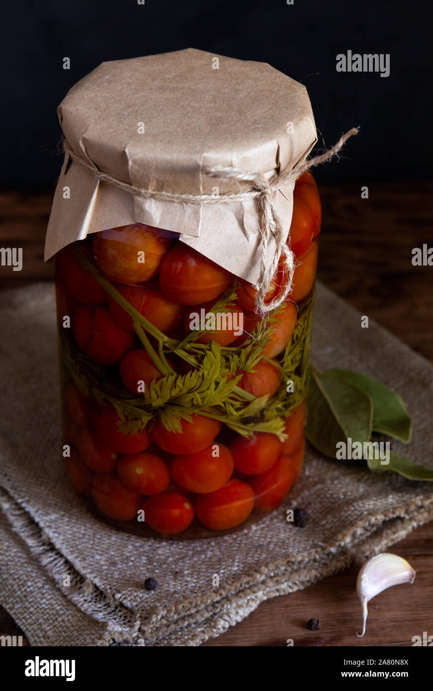 Fermented cherry tomatoes in a jar. Pickled vegetables on a dark ...