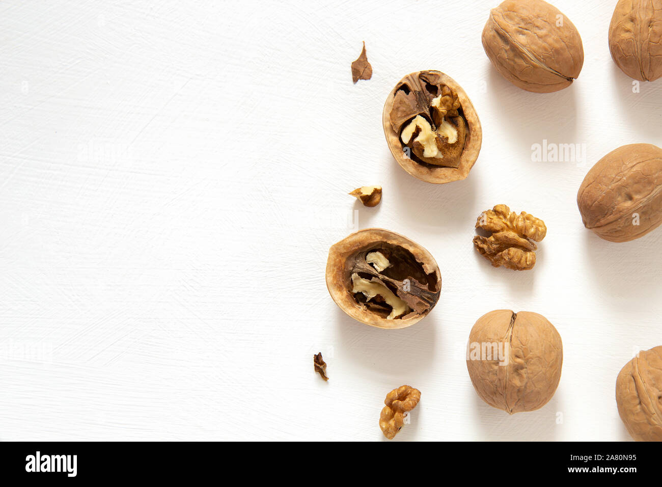Whole and chopped walnuts on a white background. Horizontal orientation ...