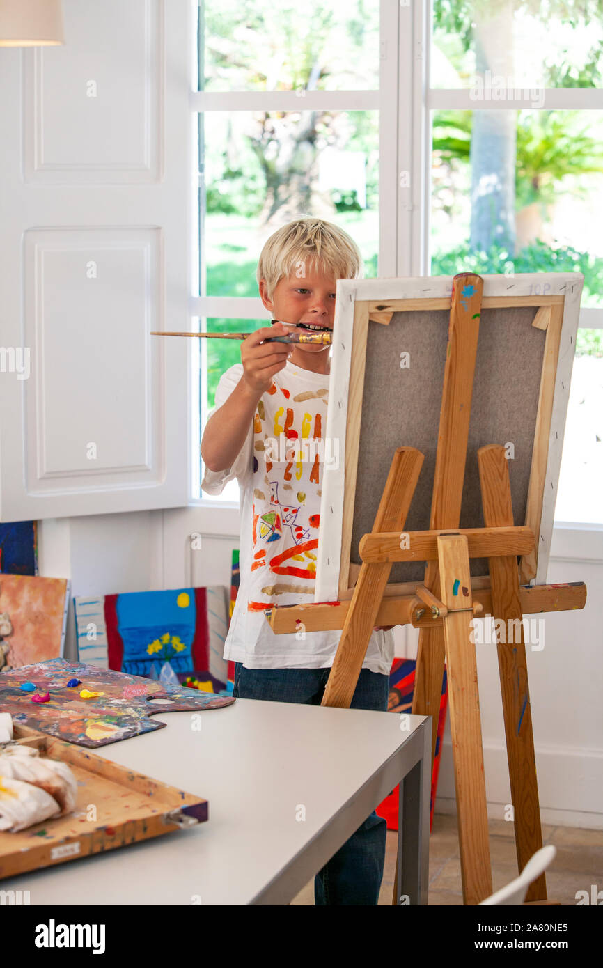Young boy painting on canvas at home Stock Photo - Alamy