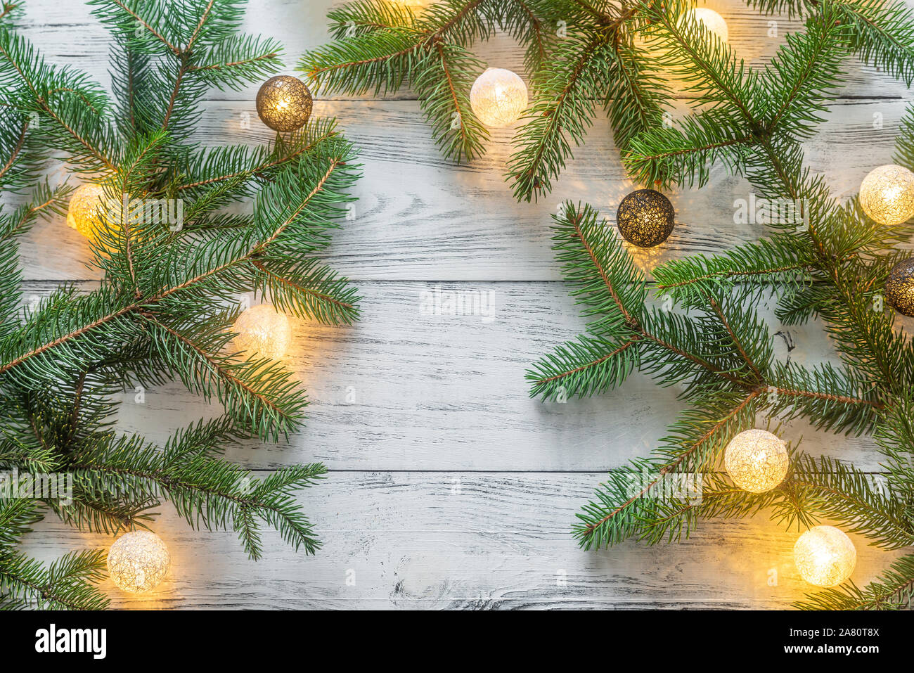 Christmas tree branches with lights on the wooden background Stock ...