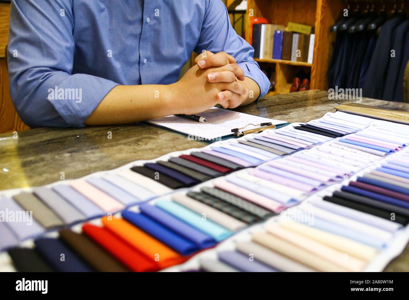 tailor choosing a fabric in swatch for his customer in tailor shop ...