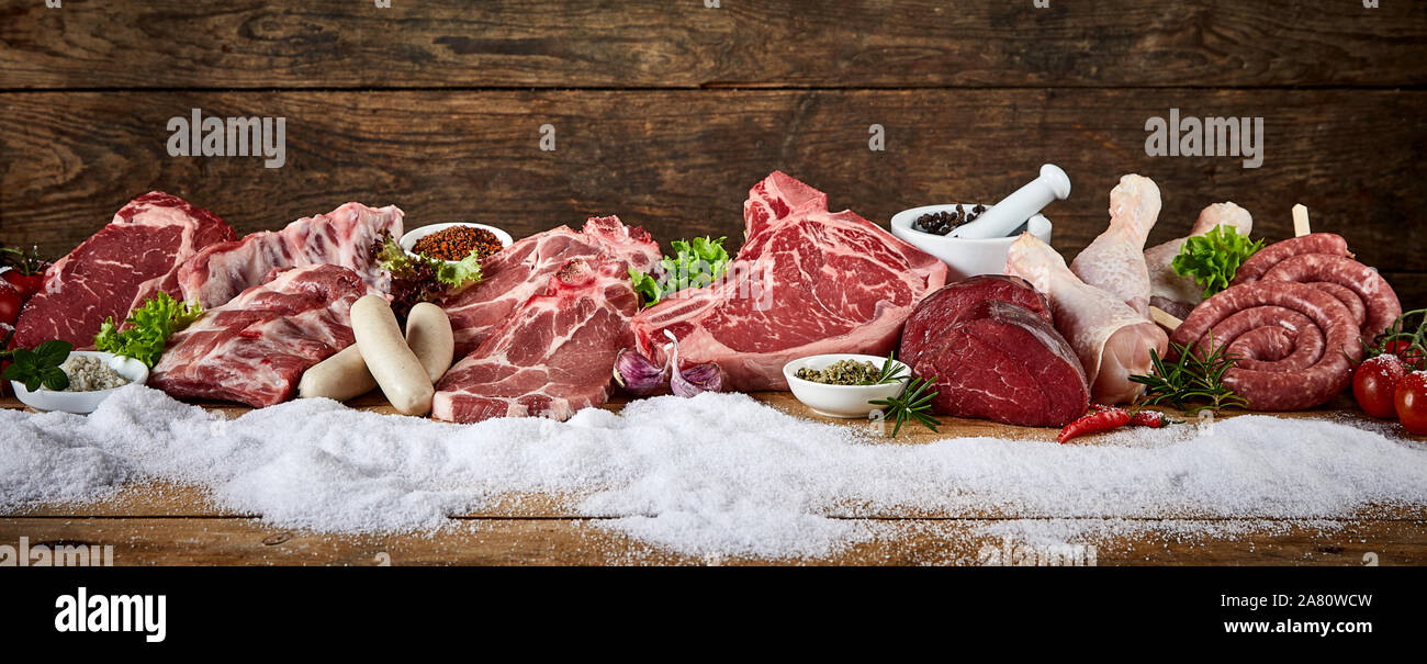 Panorama with assorted raw meat for a winter BBQ displayed on snow ...