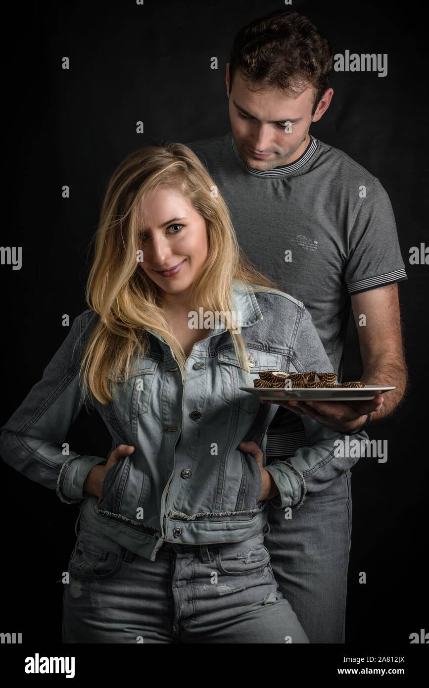 Man is tempting a girl with chocolates Stock Photo - Alamy