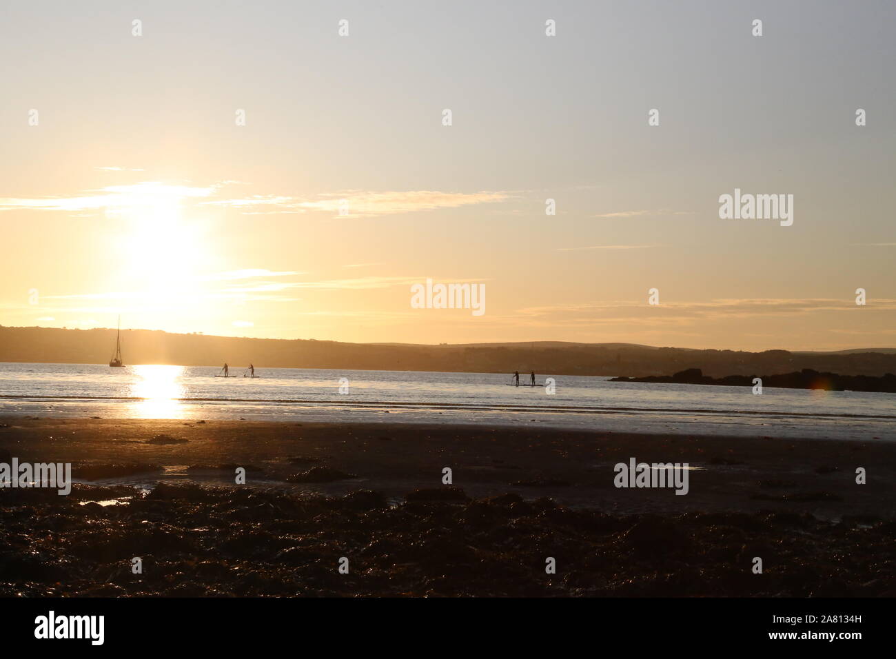 Sun setting over sea Stock Photo - Alamy