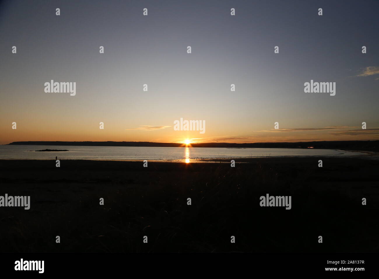 Sun setting over sea Stock Photo - Alamy