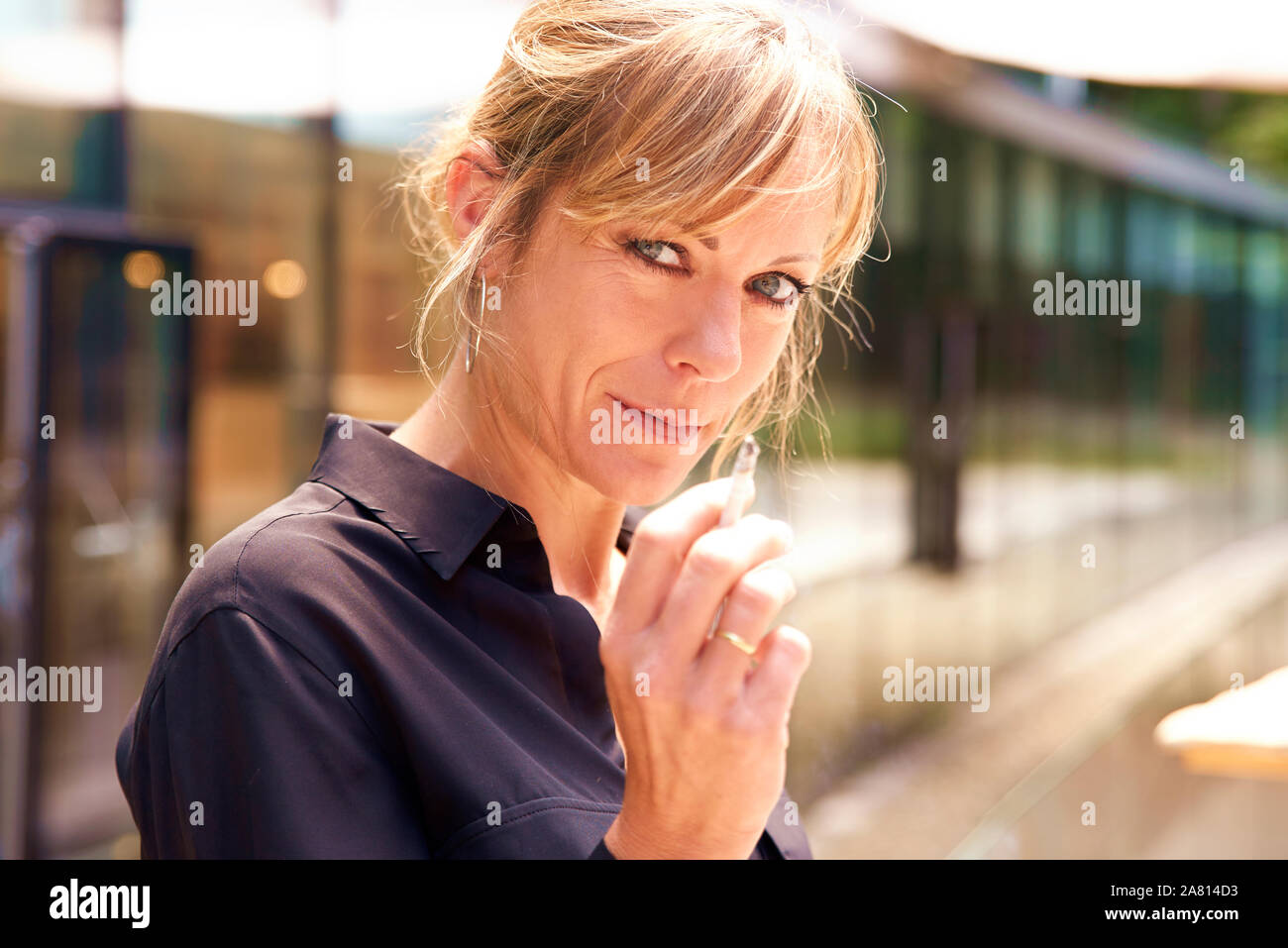 Blond female smoking cigarette hi-res stock photography and images - Alamy