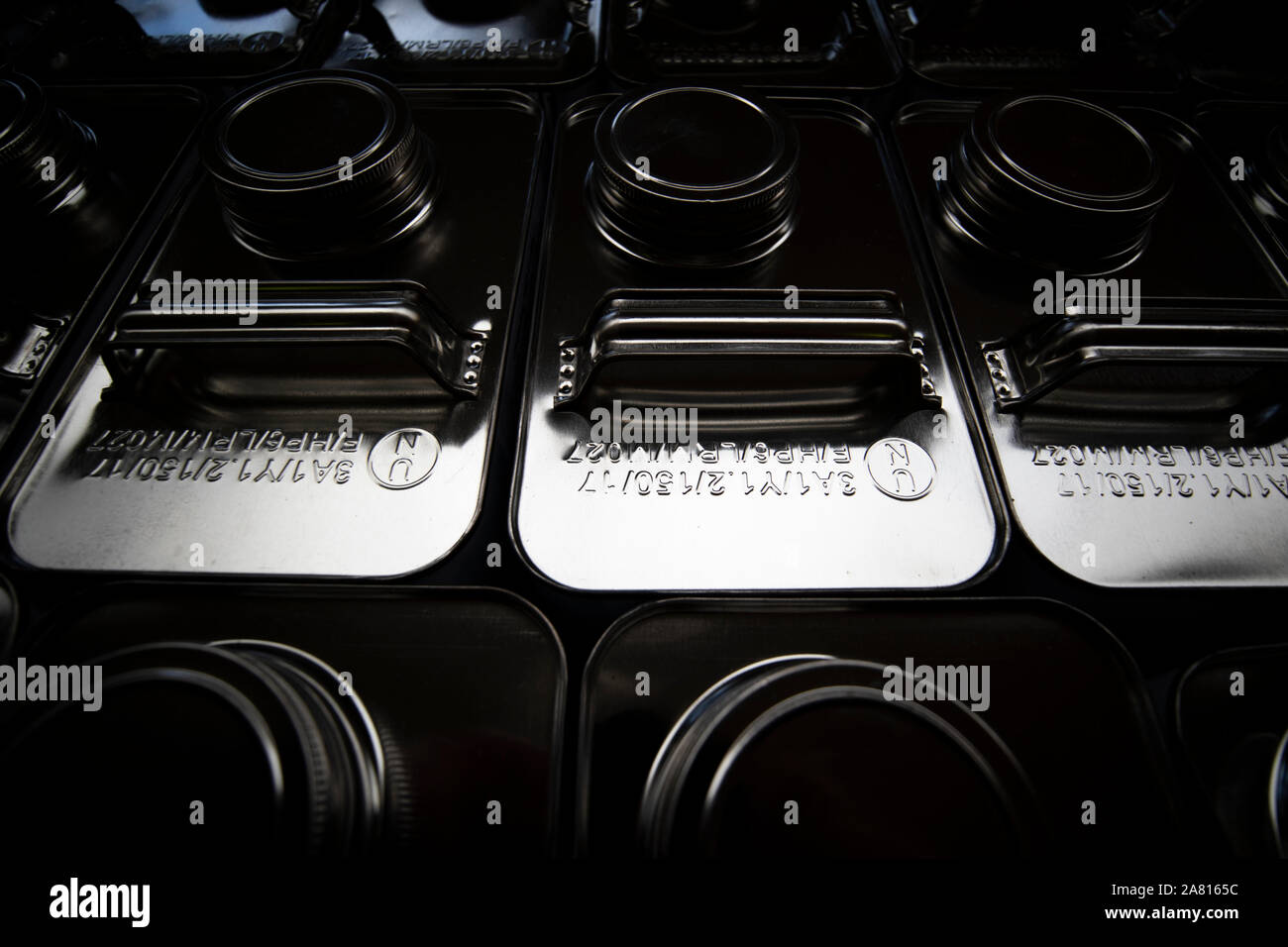 stainless steel jerry cans stacked in warehouse, close up with shallow ...