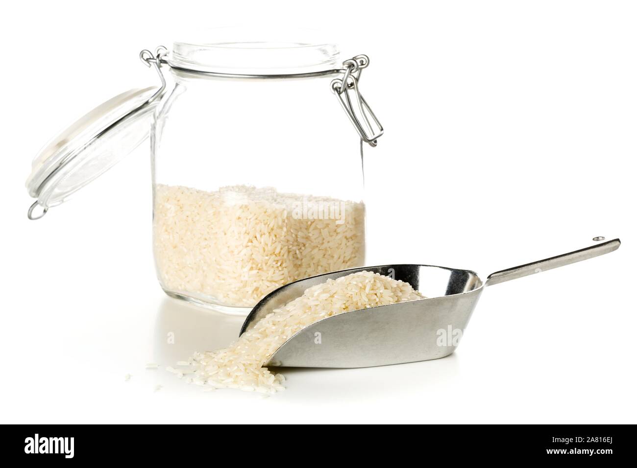 White uncooked, raw long grain rice in glass storage jar with metal ...