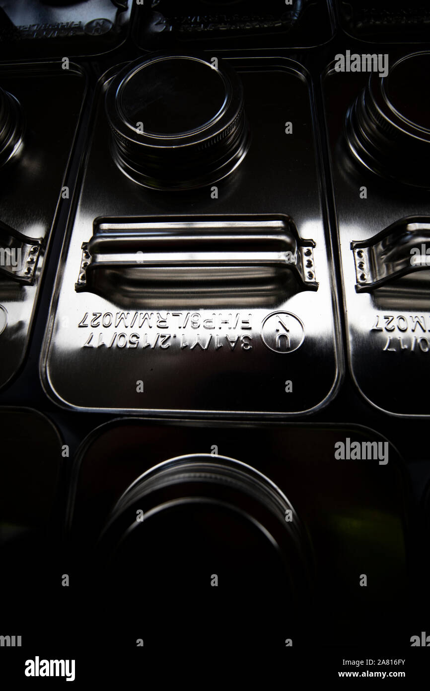 stainless steel jerry cans stacked in warehouse, close up with shallow ...