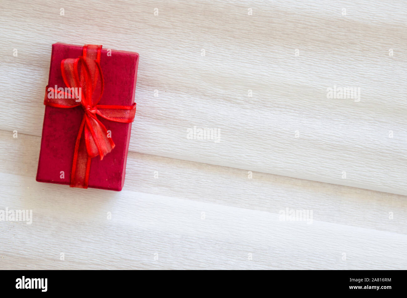 present in red box with red ribbon on white background Stock Photo - Alamy