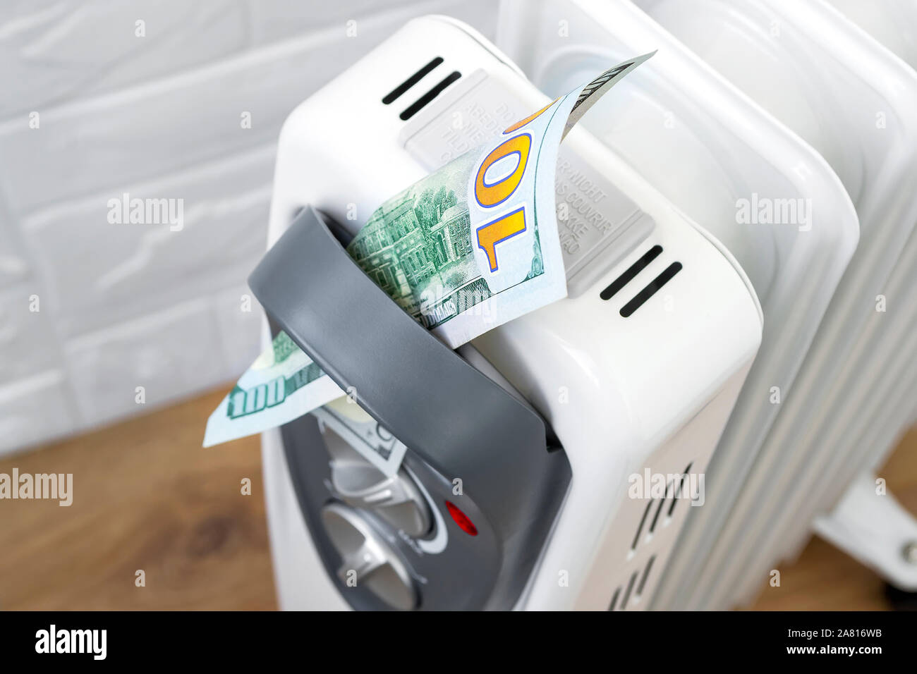 One hundred dollar bill in a handle of home electric oil radiator ...