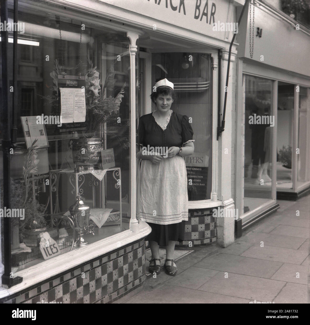 1950s, historical, a uniformed waitress standing for her photo outside ...