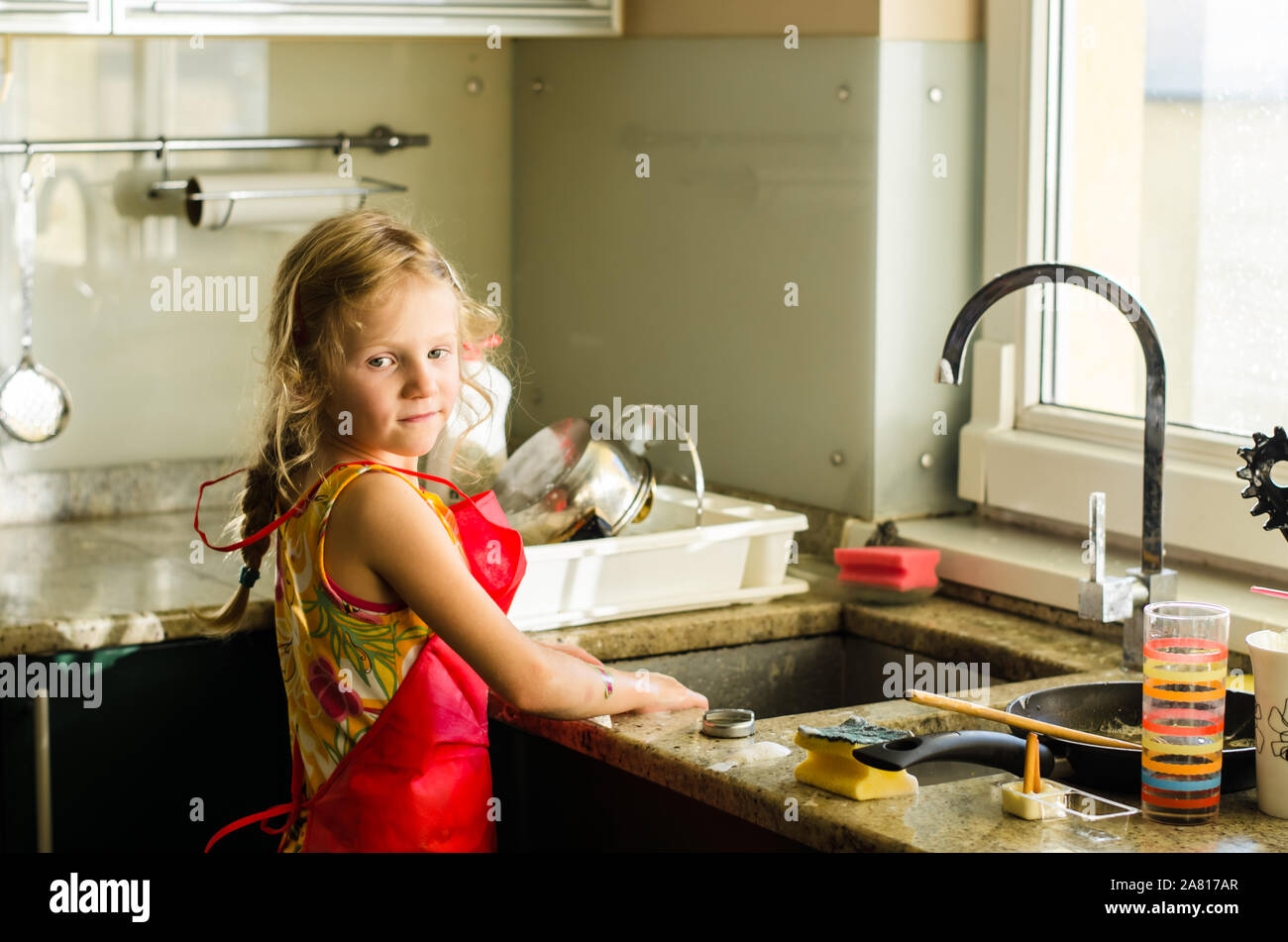 little child washing dishes in the kitchen Stock Photo - Alamy