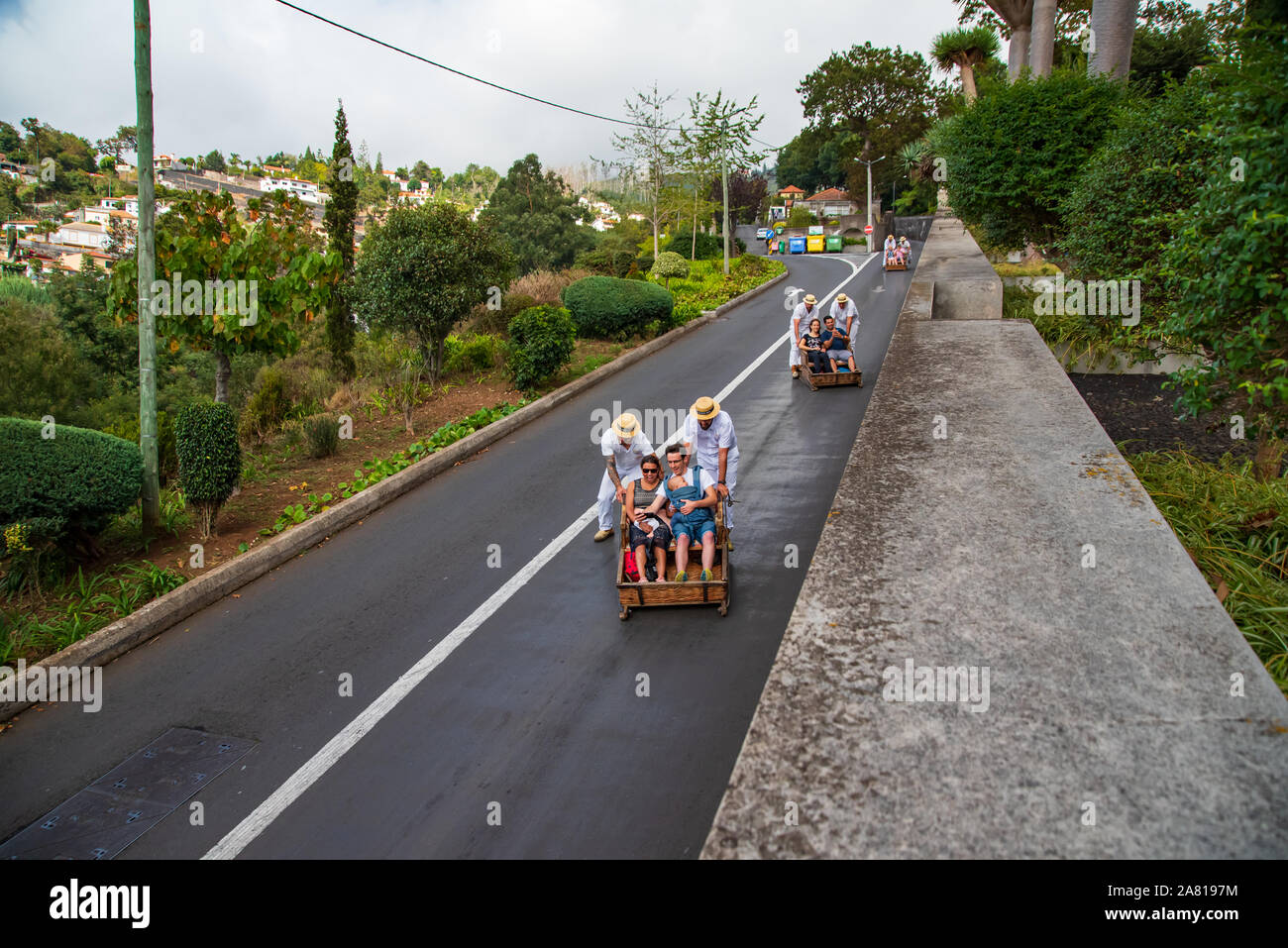 Tourists enjoying a traditional basket sled ride in Funchal, Madeira ...