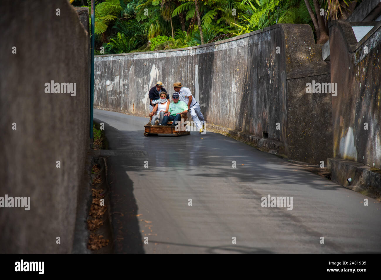 Tourists enjoying a traditional basket sled ride in Funchal, Madeira ...