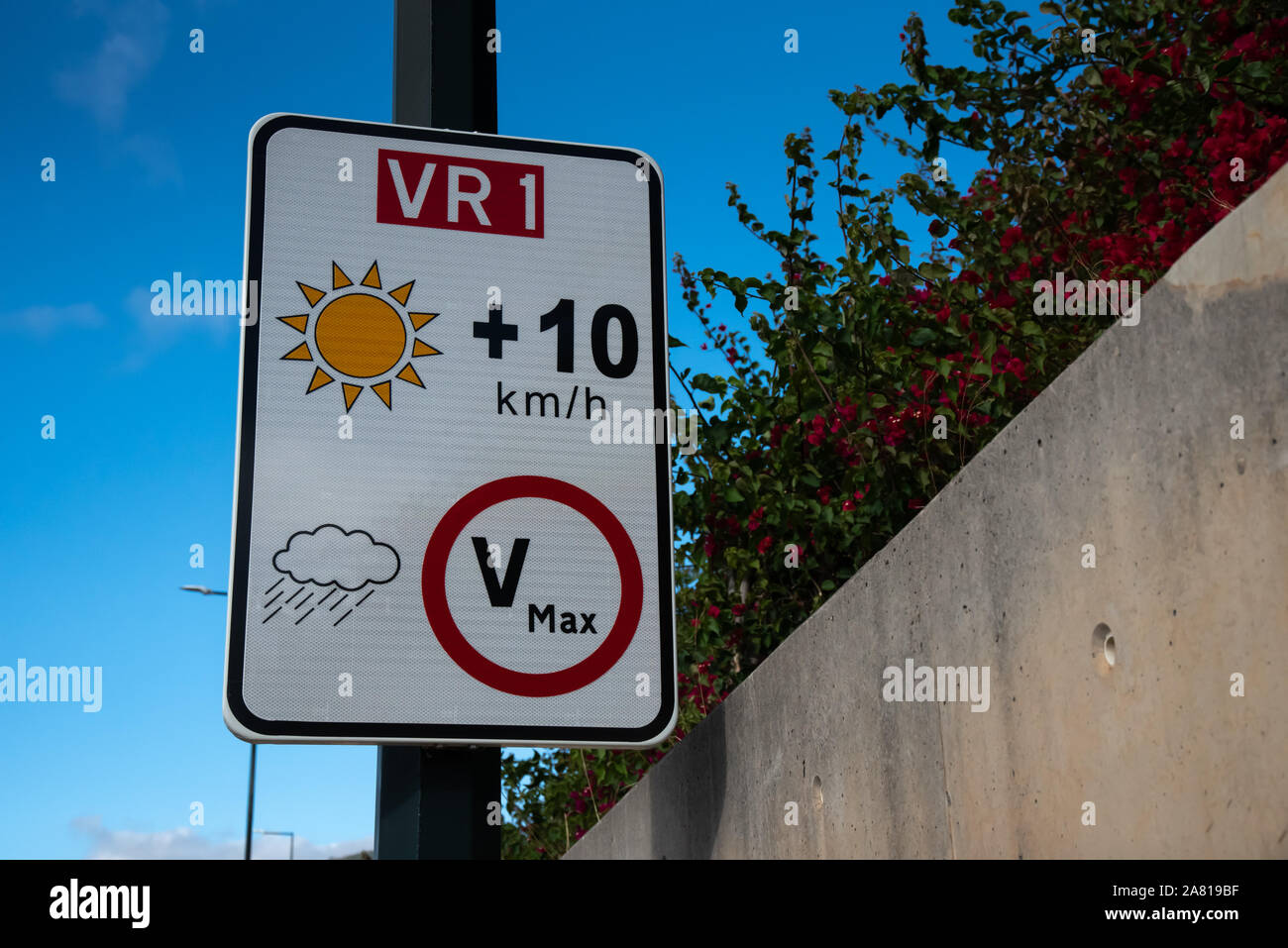 Traffic sign indicating speed adjustments based on weather conditions ...
