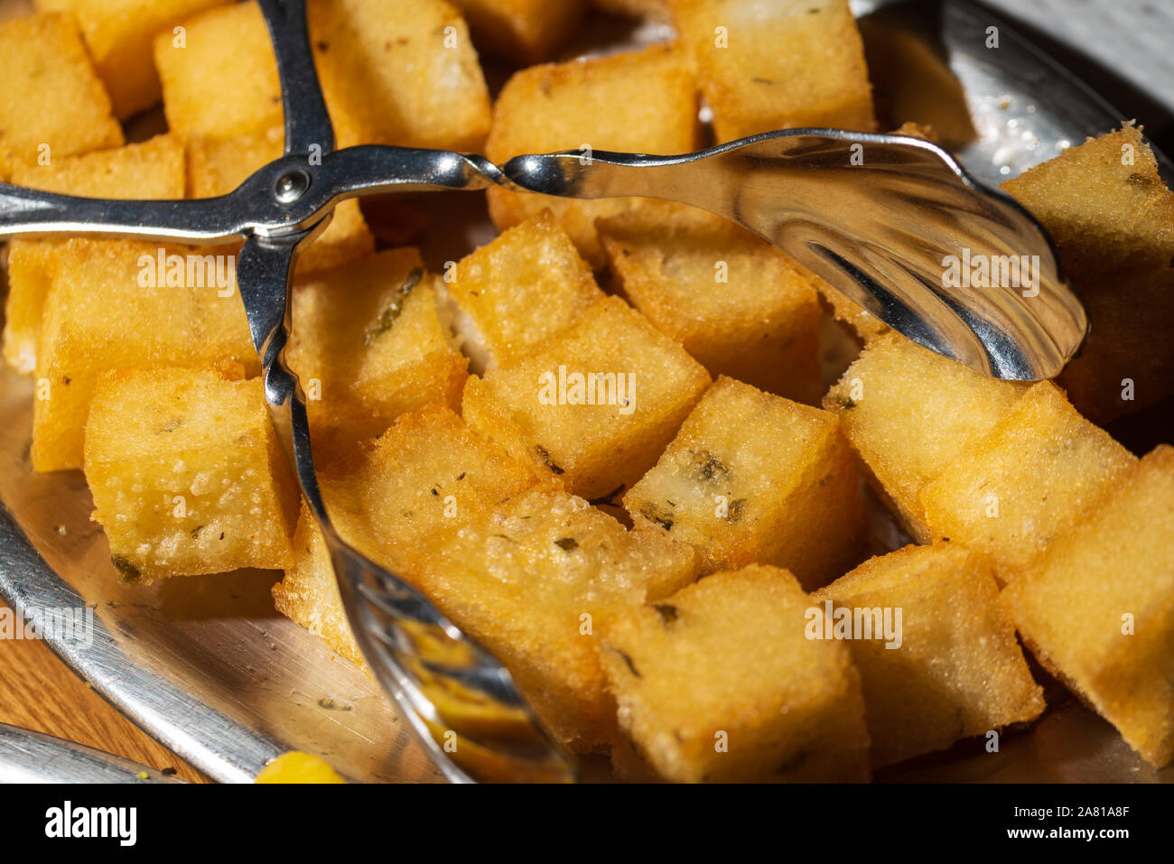 Close-up of traditional fried cornmeal cubes, a typical side dish from ...