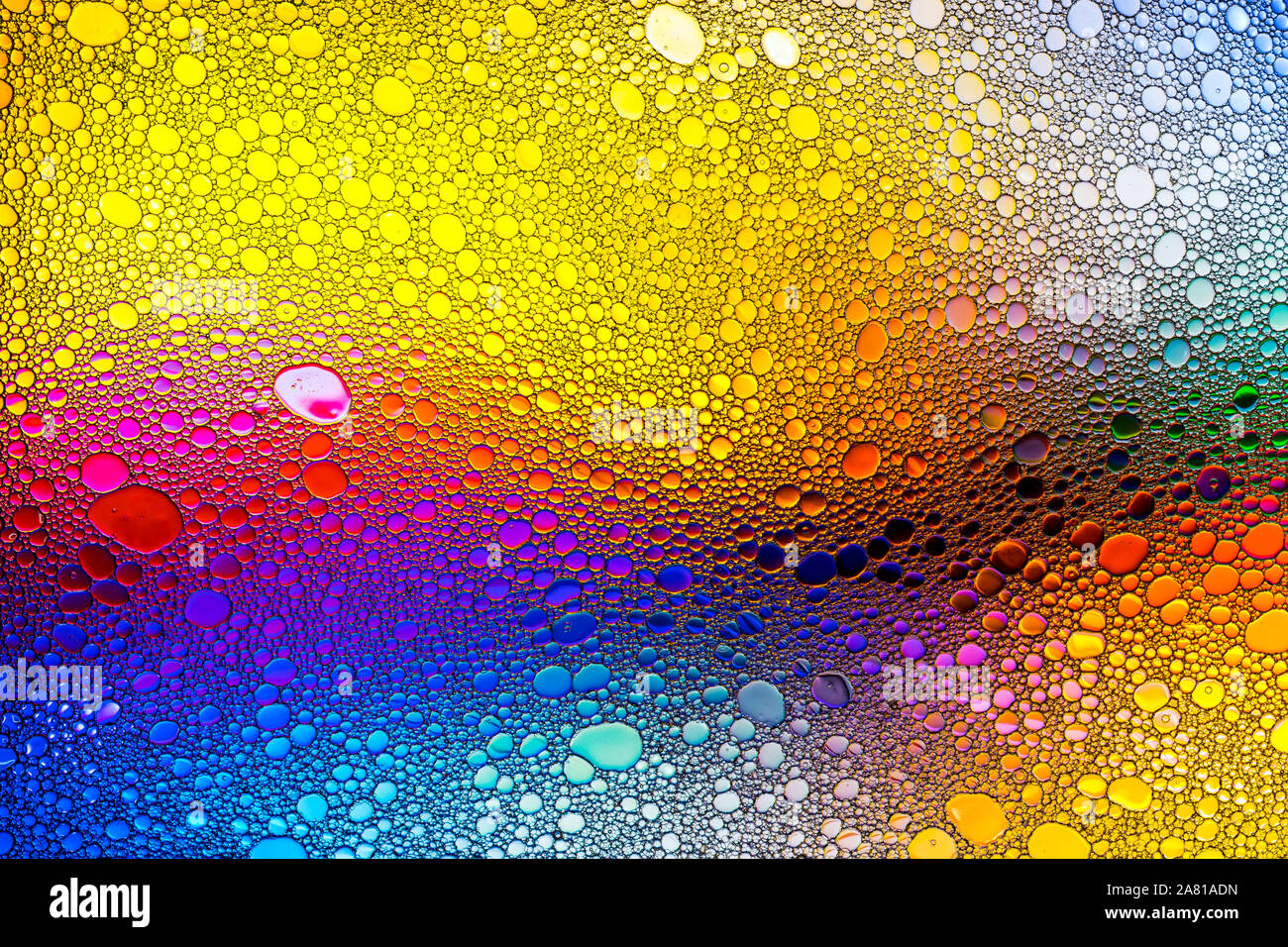Colorful drops of oil on the water. Rainbow or spectrum colored circles ...