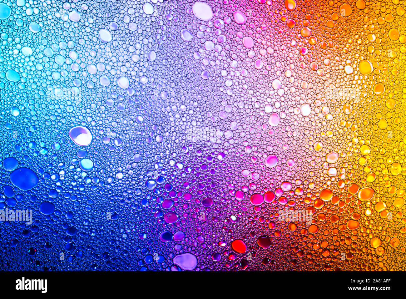 Colorful drops of oil on the water. Rainbow or spectrum colored circles ...