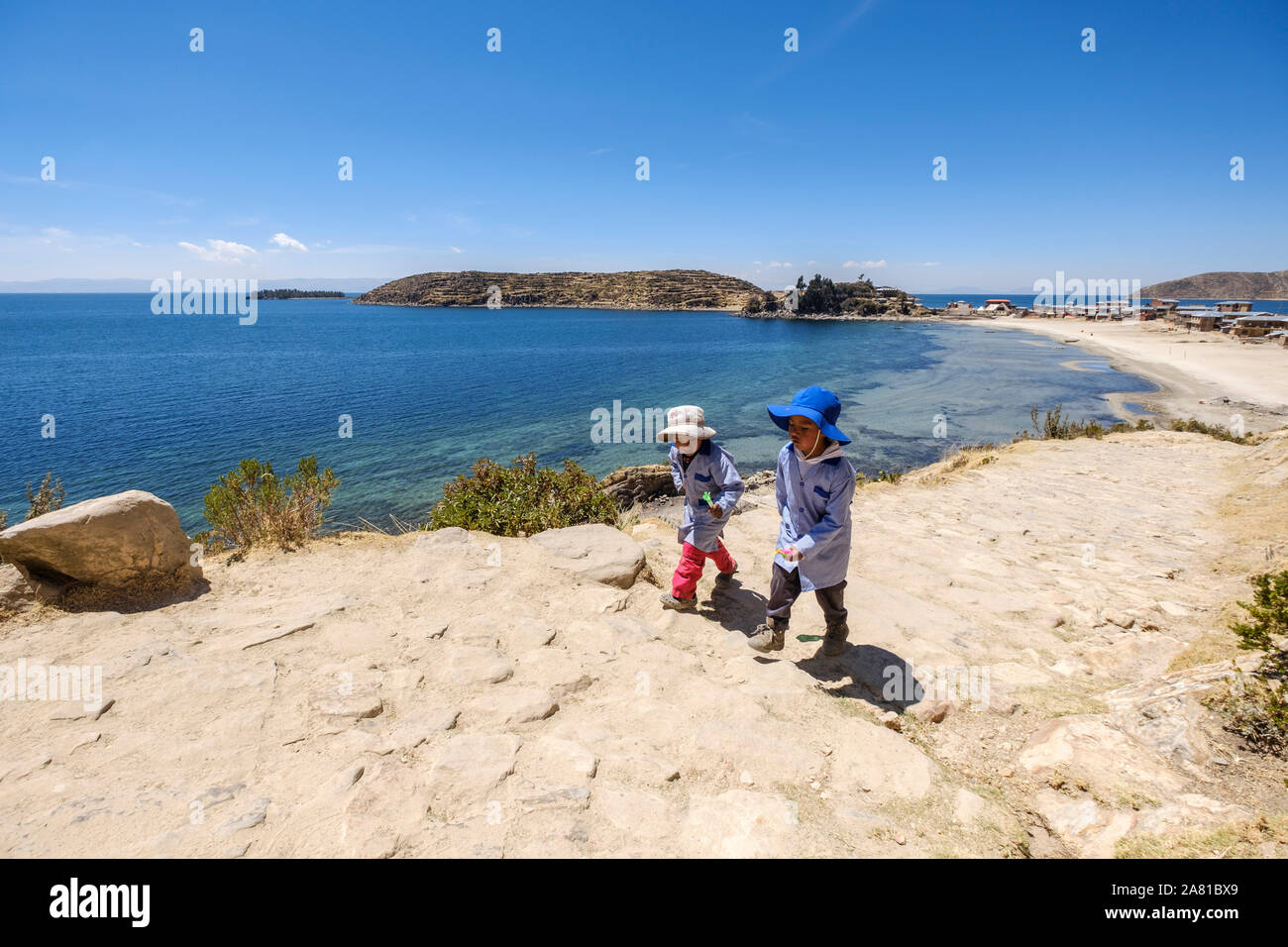 Two kids in school uniform walking on the Challa Community side of the ...