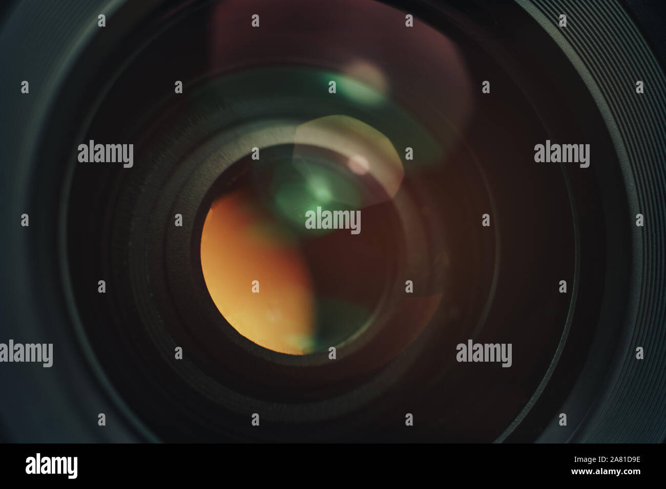 Beautiful camera lens with yellow and pink light of glass on a black ...