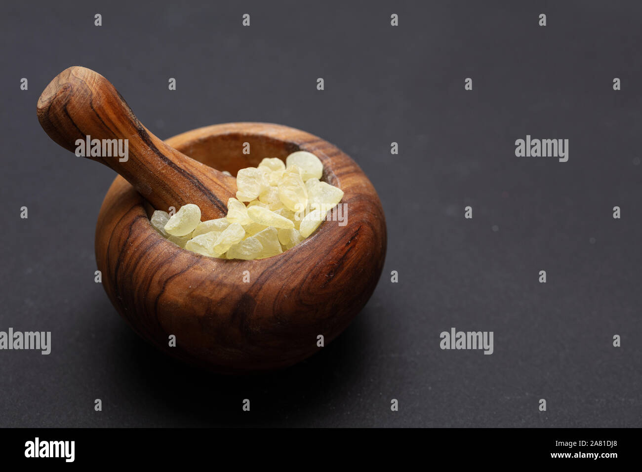 Mastic resin tears. Chios mastic in a wooden mortar isolated on black ...