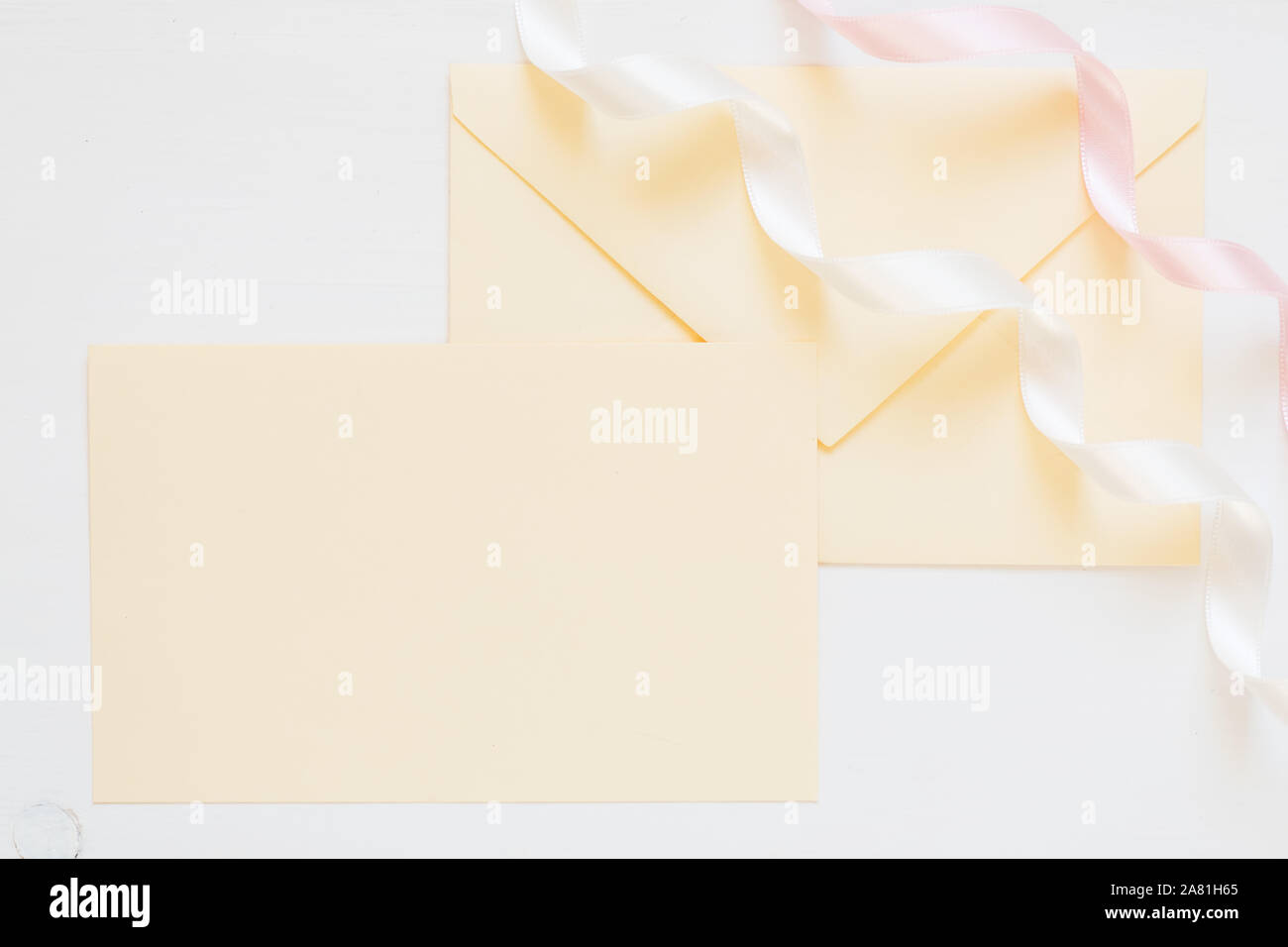 blank cream-colored envelope with ribbons, mock up for romantic ...