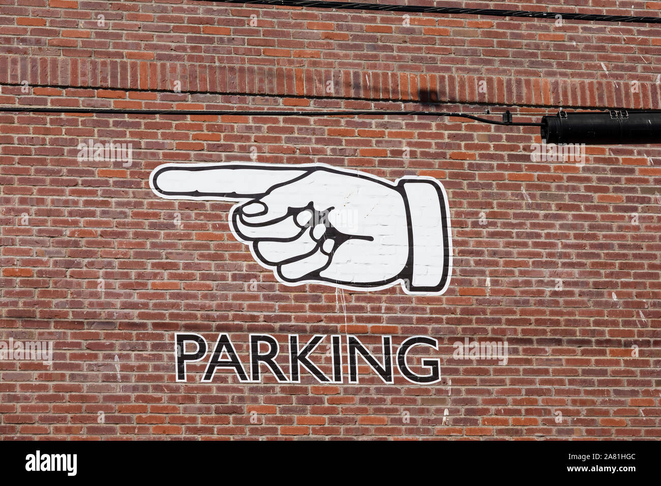Parking sign with hand pointing on brick wall, Cannery Row, Monterey ...
