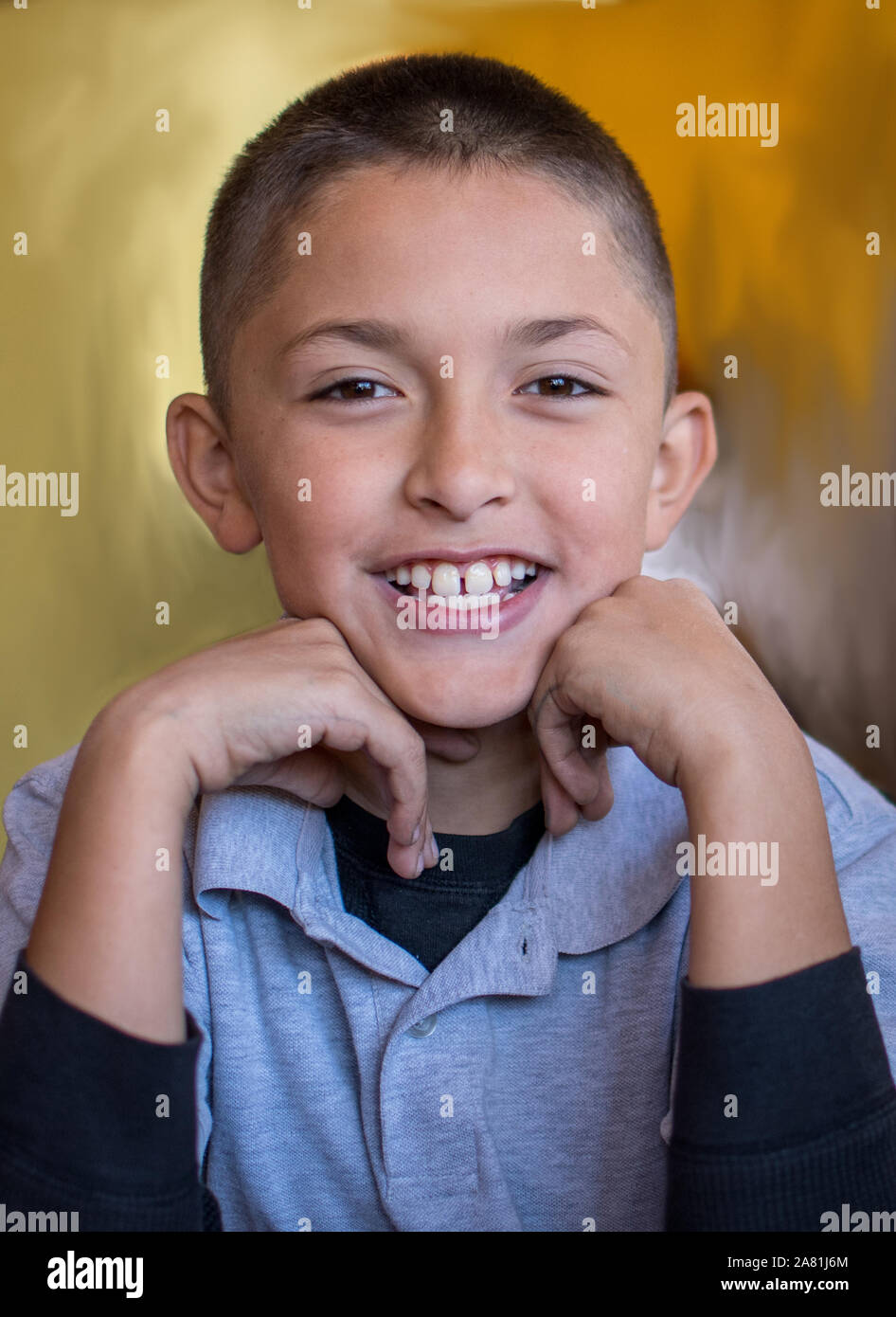 Portrait of a smiling hispanic boy with hands under his chin Stock ...