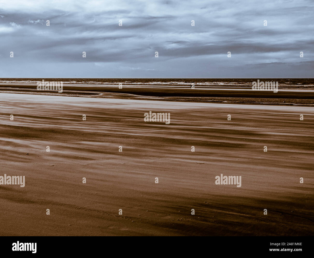 Distant couple walking alone at a windy beach in France Stock Photo - Alamy