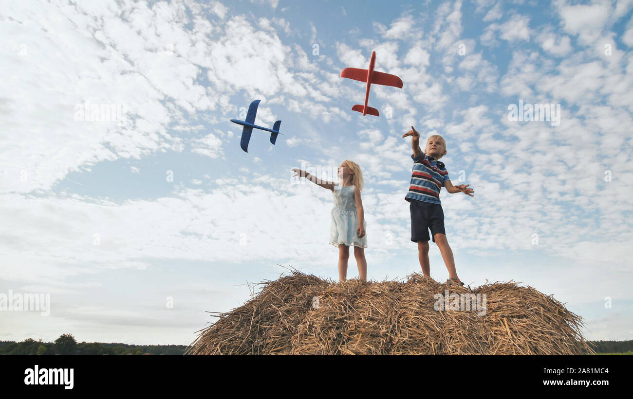 Children launch airplanes standing on a stack of straw Stock Photo - Alamy