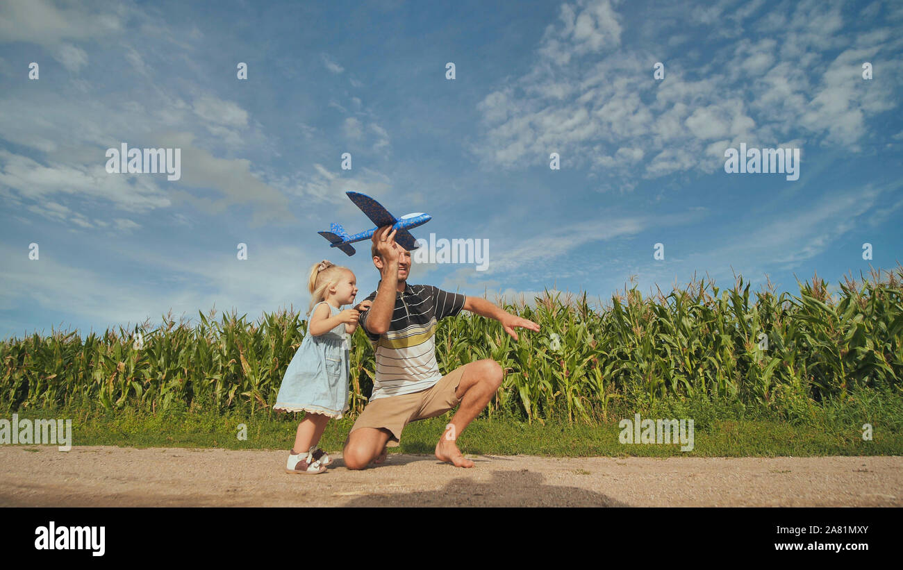 Father and little daughter launch a foam rubber toy airplane Stock ...