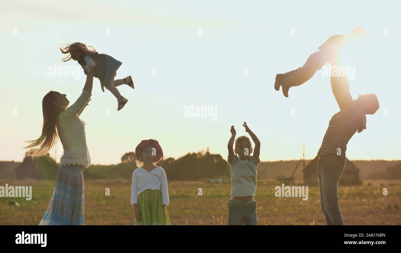 The concept of a happy large family. Happy parents tossing their ...