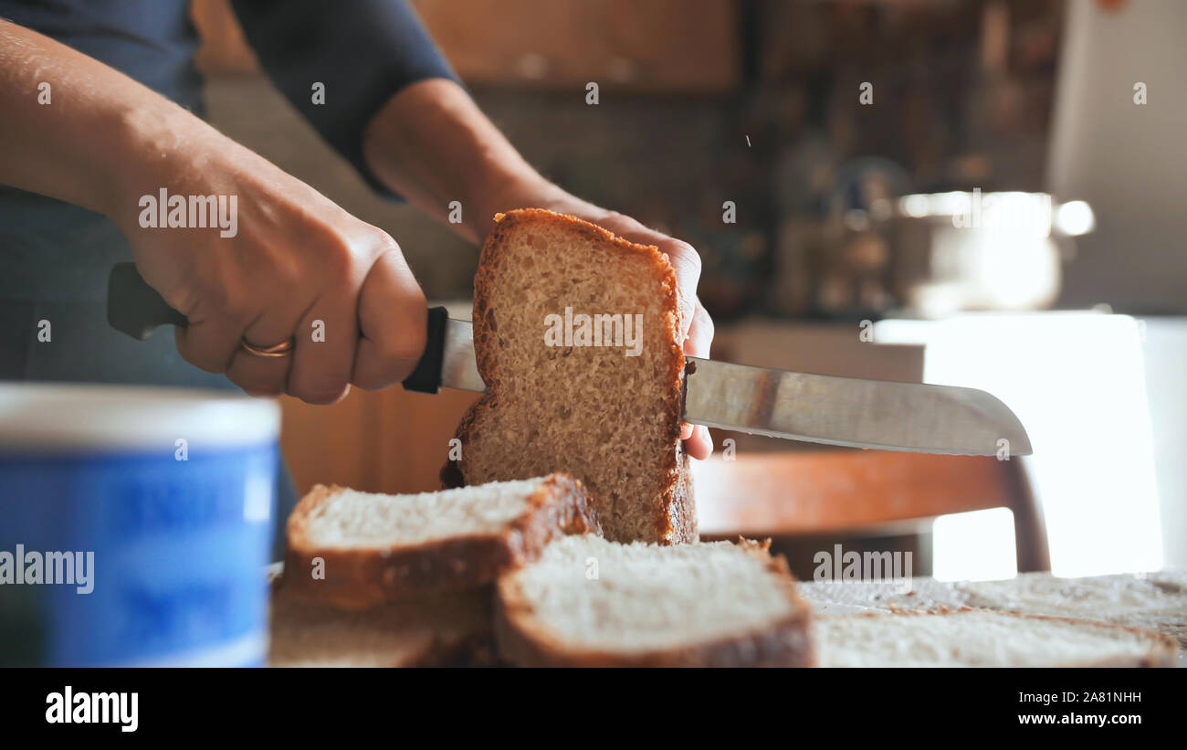 Baker cuts bread in kitchen hi-res stock photography and images - Alamy