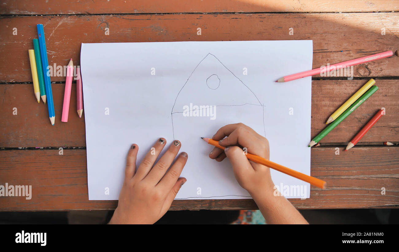 Child draws a pencil drawing of the house and his family. New home ...