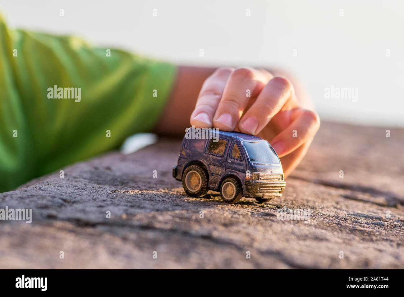Young boy plays with toy car. Little boy playing with car toy on sunset ...