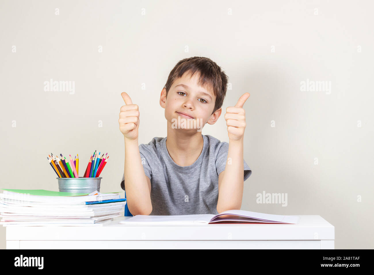 Happy boy making homework tasks and showing thumbs up sign Stock Photo ...