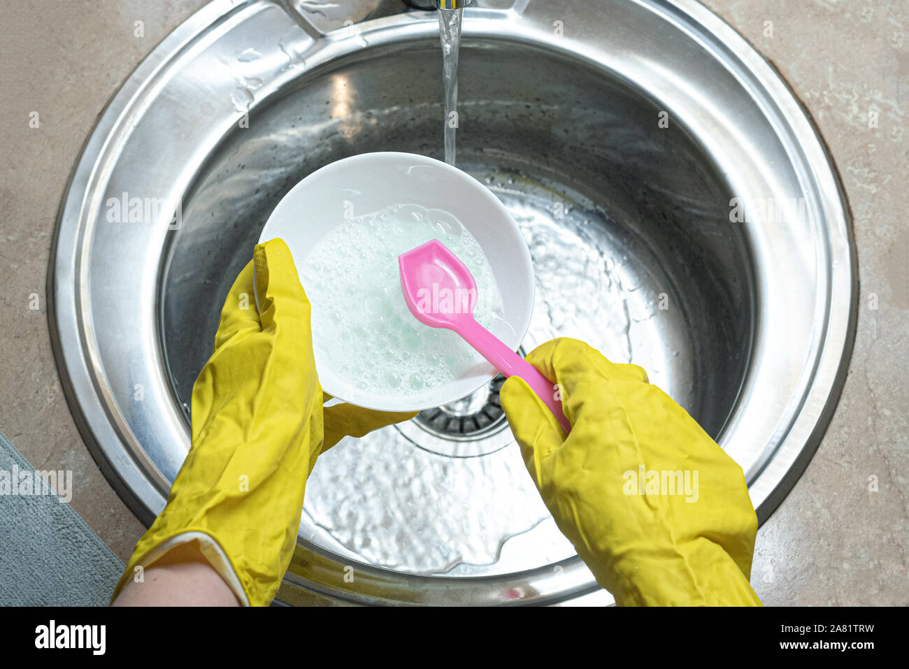 Woman is washing a dishes by the brush in the kitchen sink. Dish ...