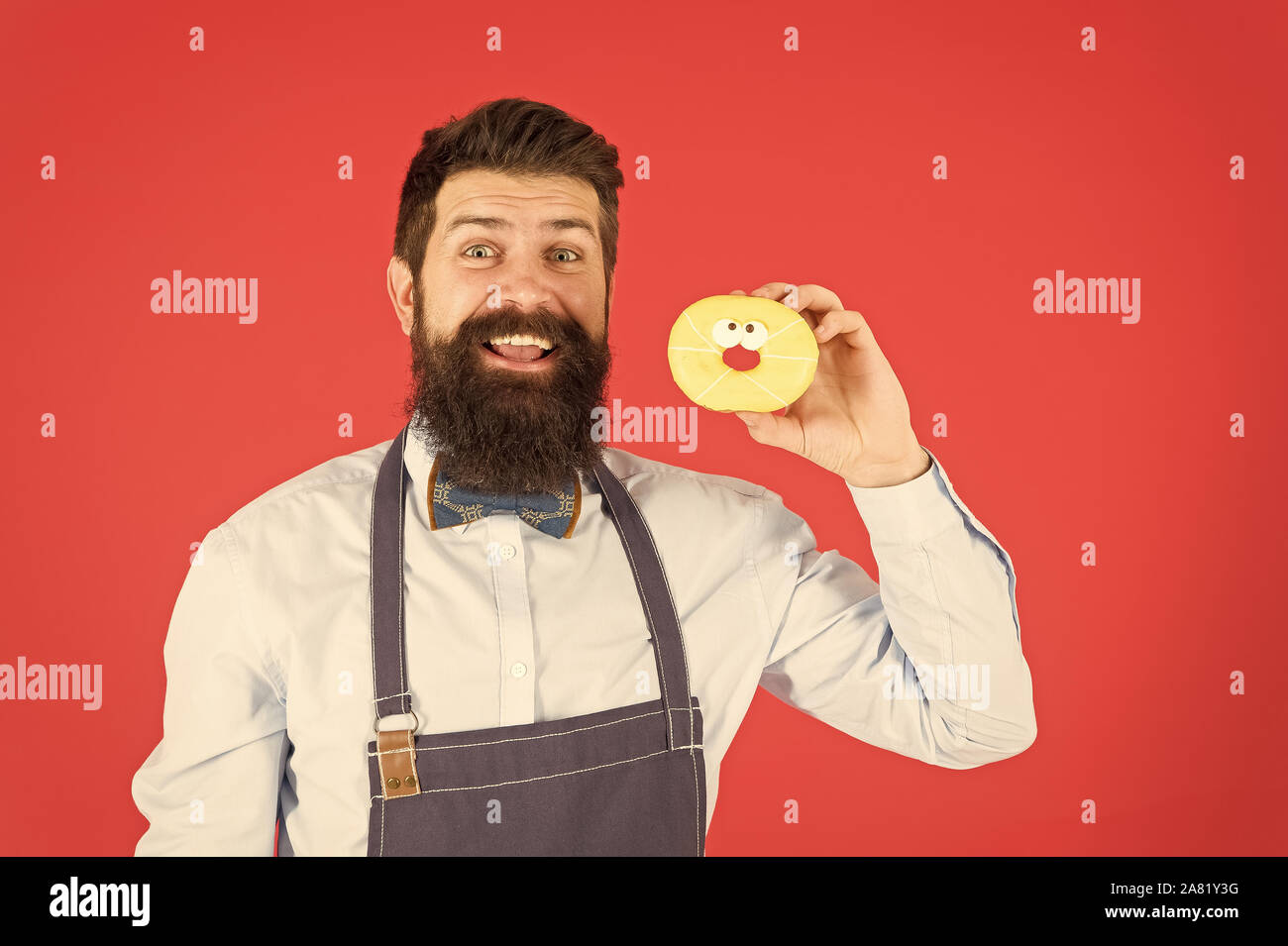 Glazed donut. Bearded well groomed man in apron selling donuts. Donut ...