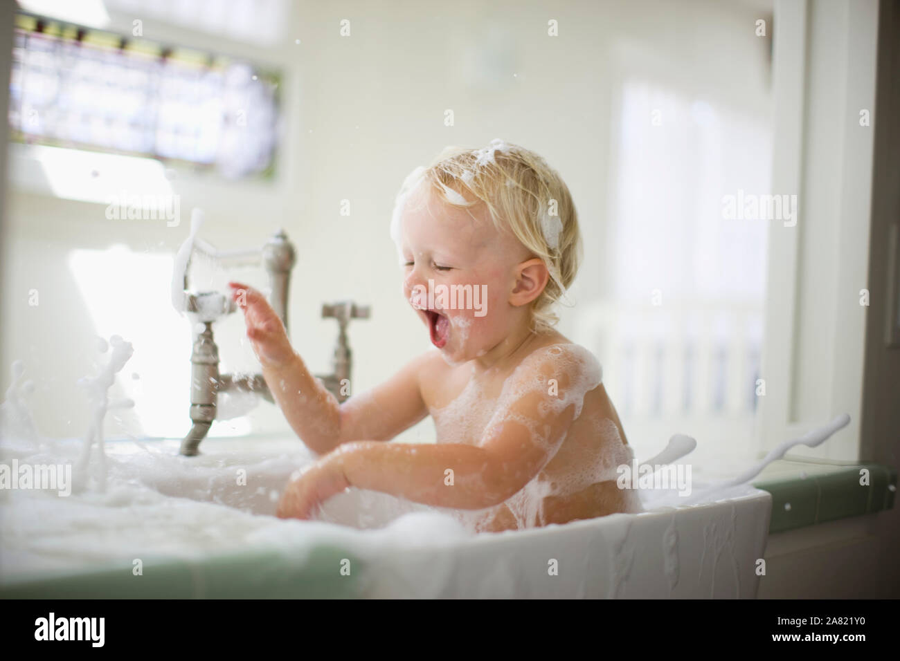 Laughing toddler having fun while taking a bubble bath Stock Photo - Alamy