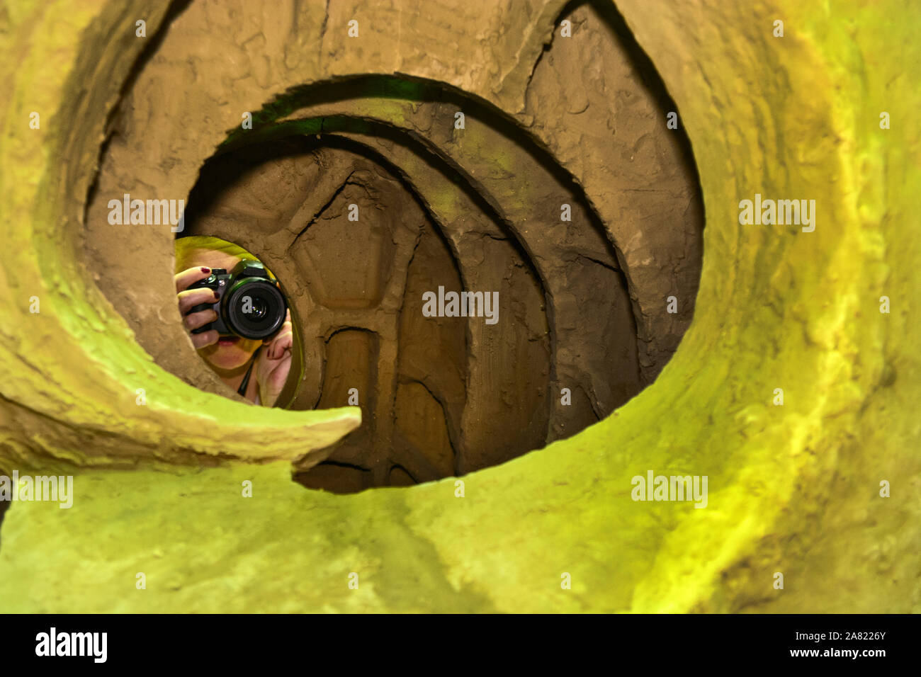 A young woman is photographing the interior of an interesting object ...