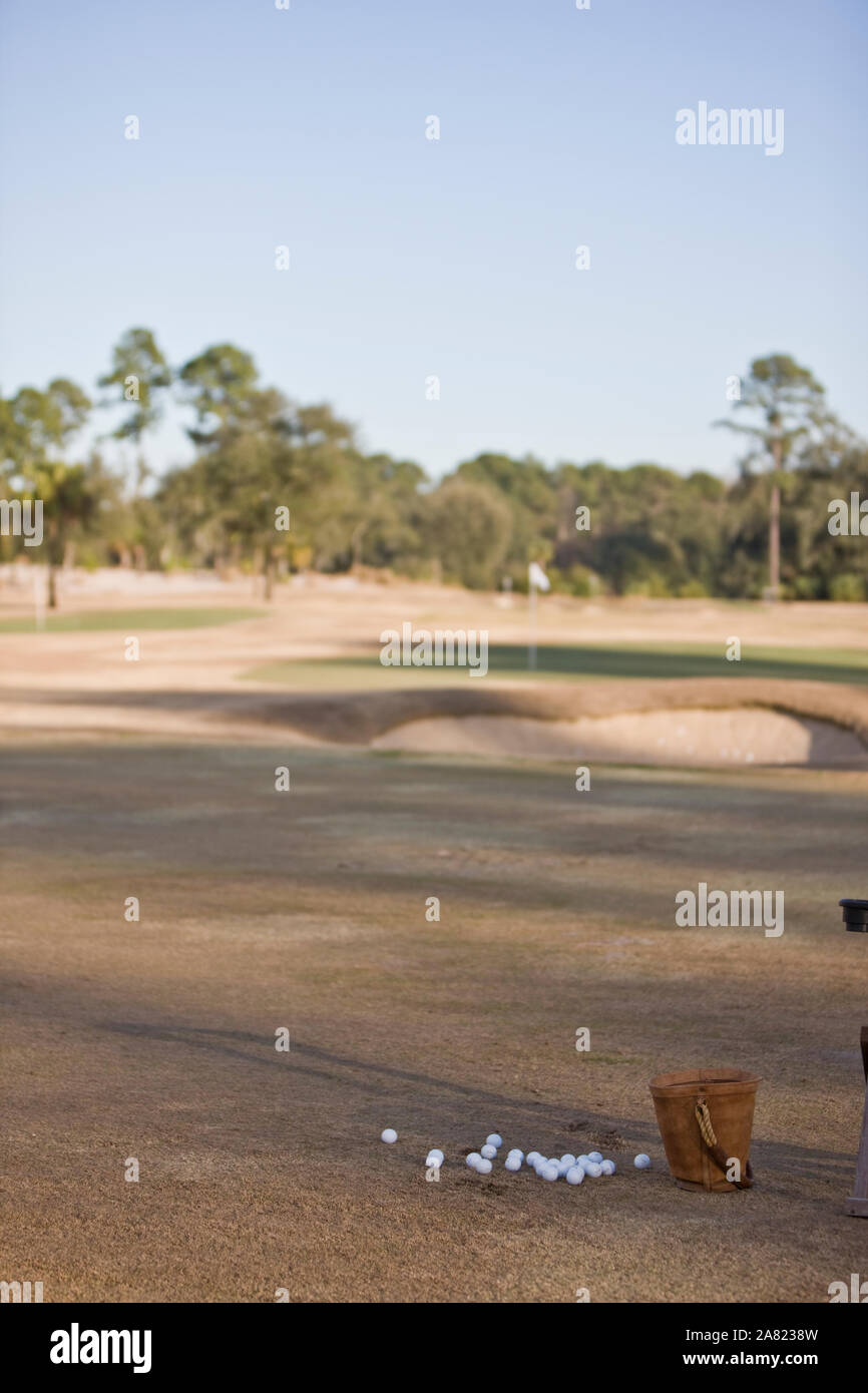 Golf course with bucket and golf balls Stock Photo - Alamy