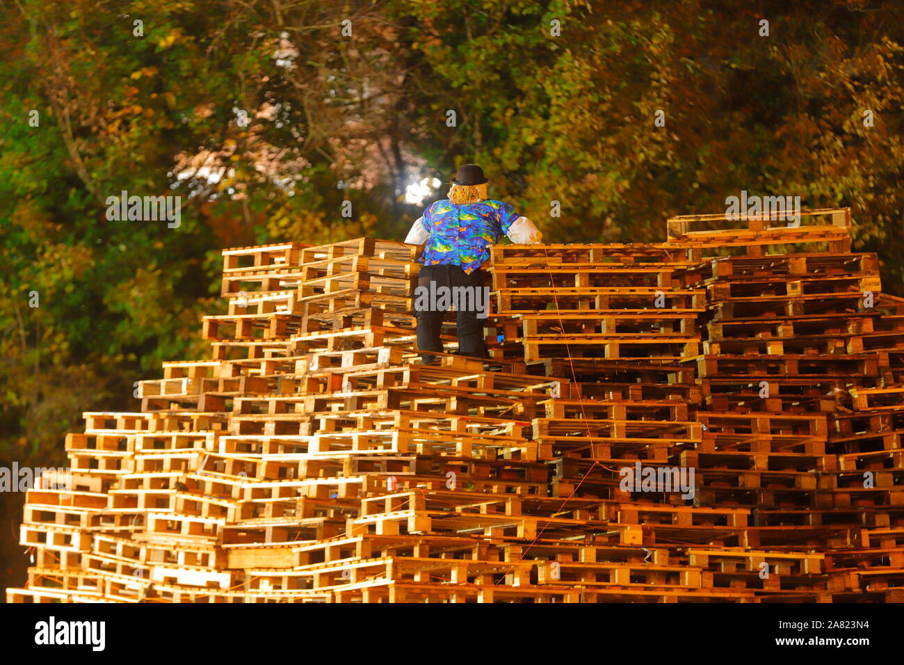 A Guy Fawkes bonfire mascot sits on top of a bonfire waiting to be lit ...