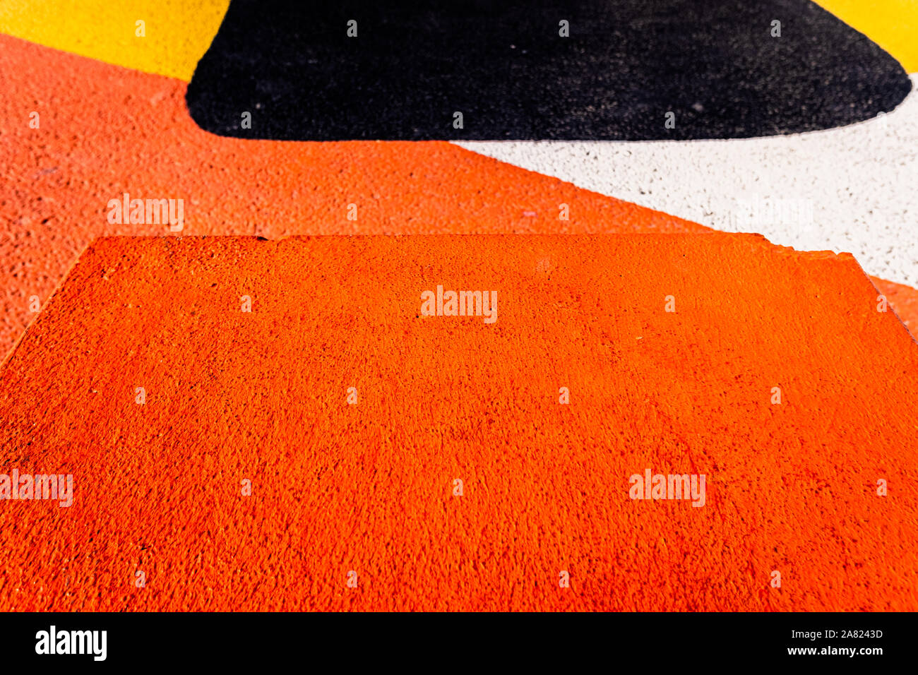 Asphalt floor painted in orange, with concrete blocks of harsh shadows ...