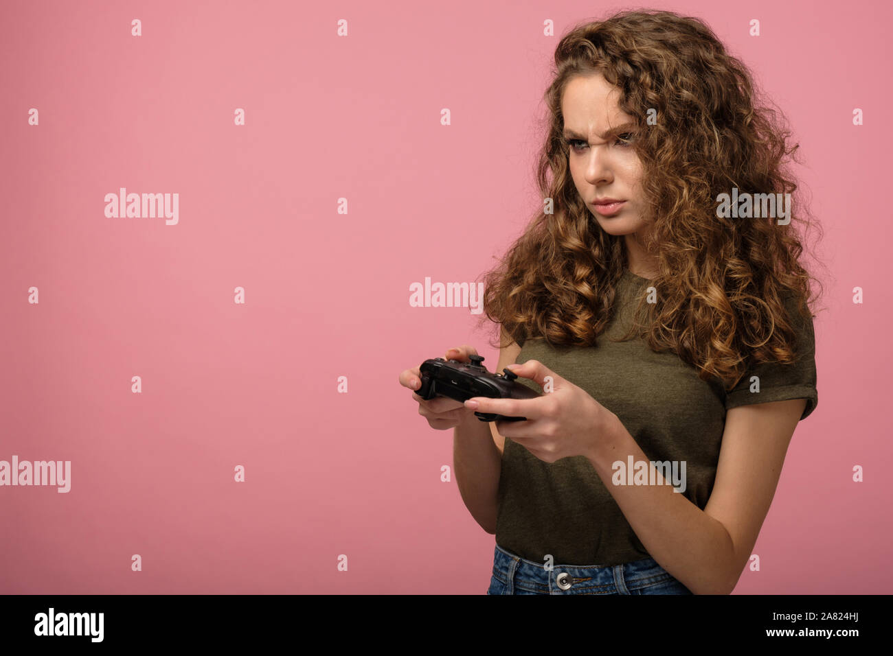 Pretty gamer girl with curly hair holding gaming controller and ...