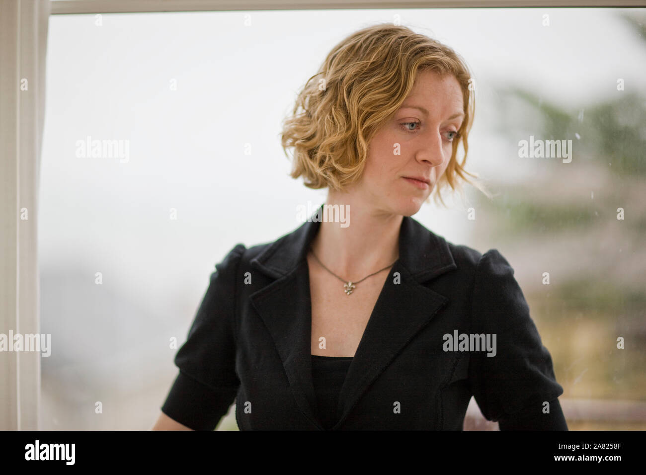 Portrait of serious woman standing next to window Stock Photo - Alamy
