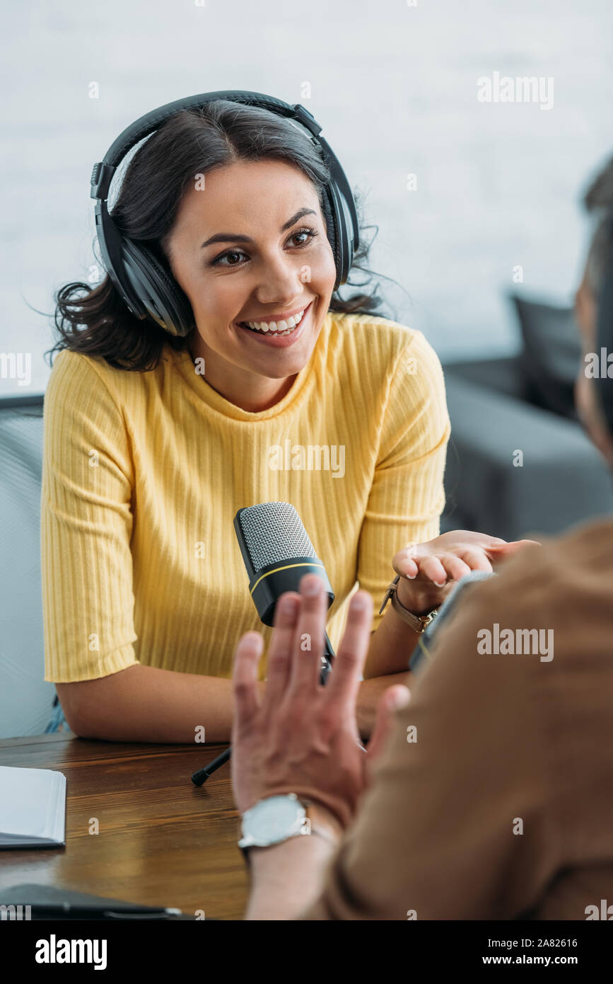 attractive radio host smiling while talking to colleague in ...