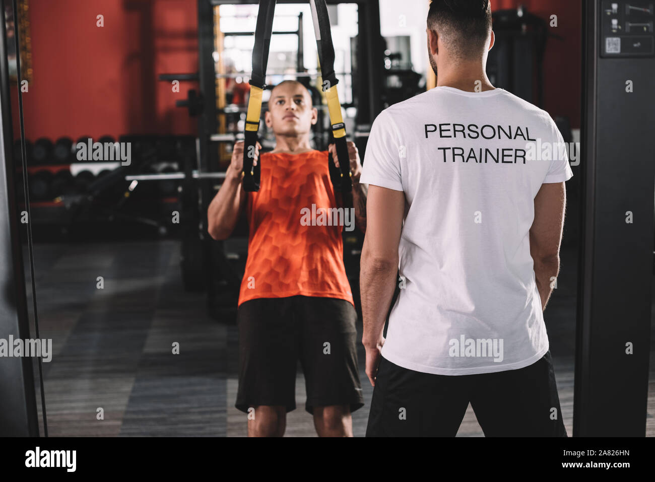 back view of personal trainer standing near young african american ...