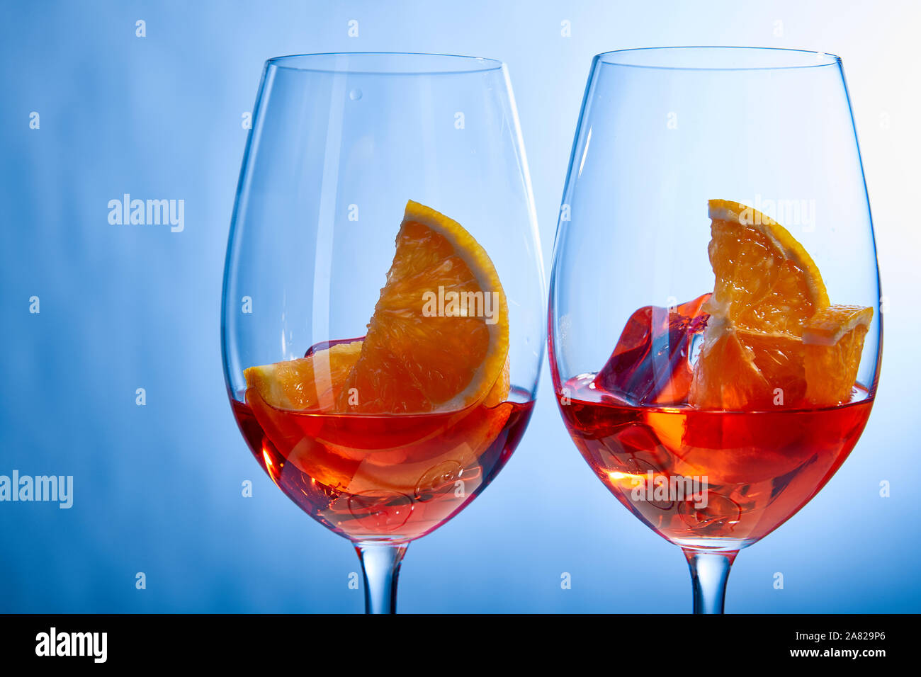 cocktails Aperol Spritz with ice cubes in glasses on blue background ...